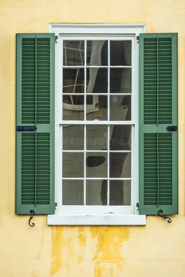 A Colonial Ear Window with Green Shutters on a Yellow Brick Building ...