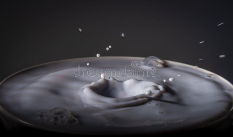 Color Fresh Milk Drops into Another Color of Milk in Cup with Dark ...