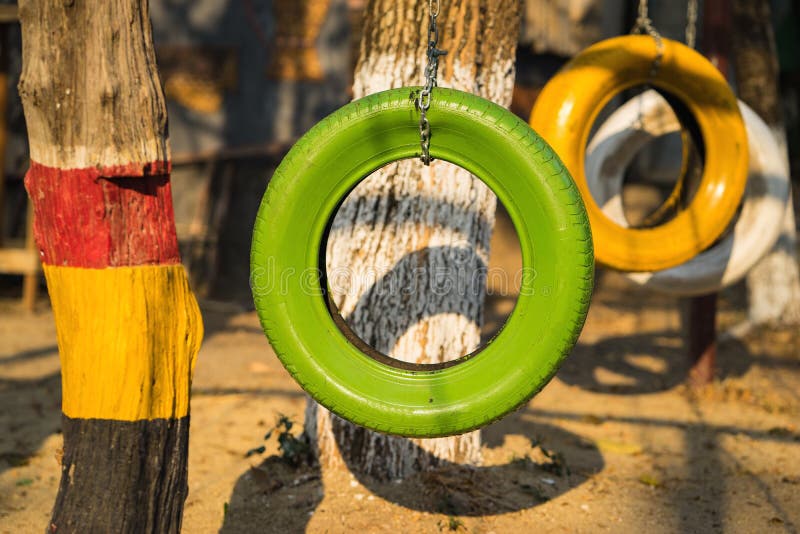 Color Old Car Tire Hanging on Tree at Playground Stock Image - Image of ...
