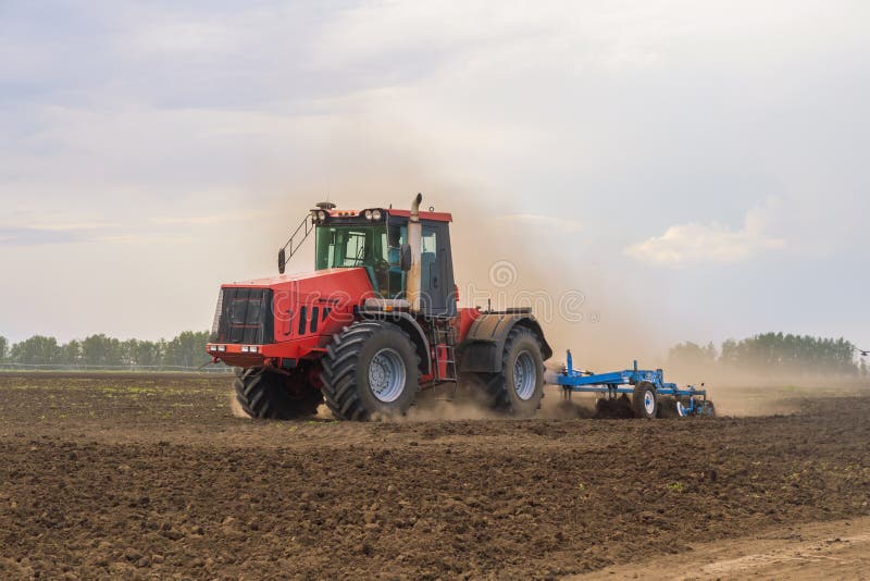 Color Photo of a Red Tractor Against the Blue Sky. Stock Image - Image ...
