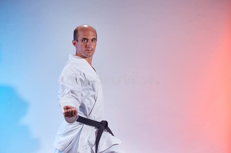 On a Colored Background, an Adult Athlete Trains Formal Exercises Stock ...