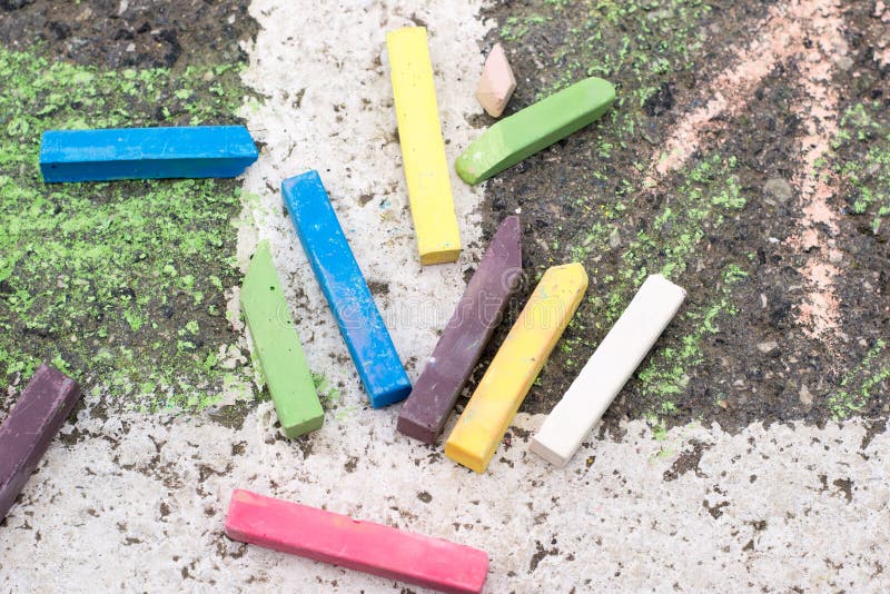 Colored crayons on asphalt stock image. Image of person - 118268887
