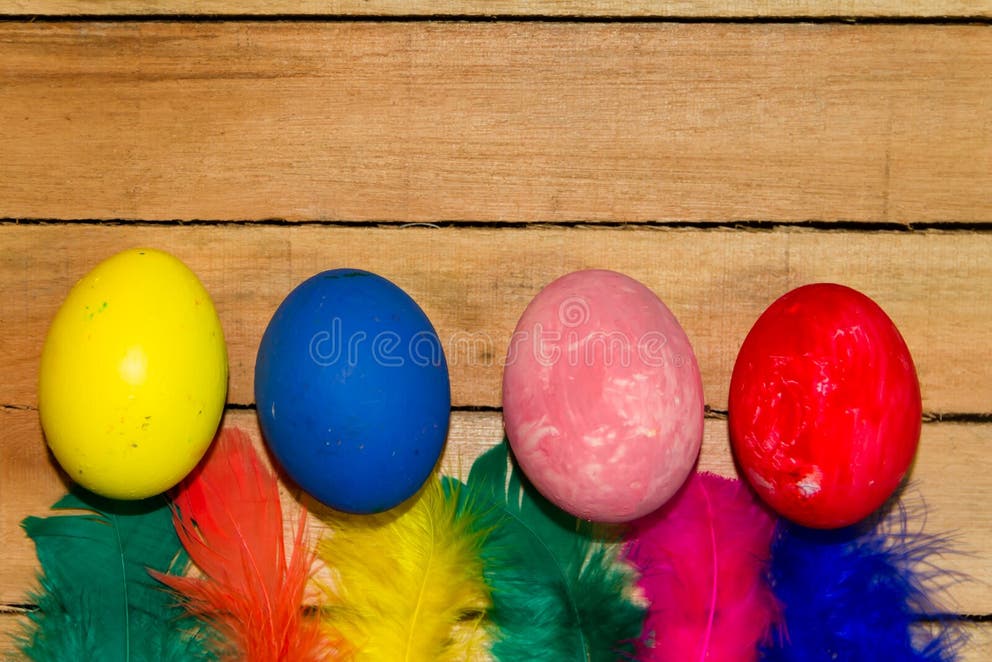 Eggs and Feathers of Easter Colors on Rustic Wooden Background Stock ...