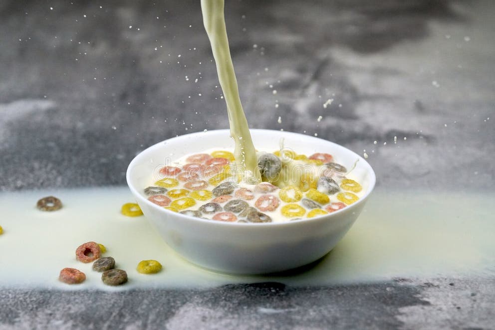 Colored Fruit Loops with Milk in a Bowl. Pouring Milk into a Bowl Stock ...