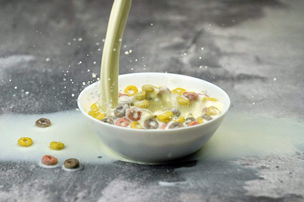 Colored Fruit Loops with Milk in a Bowl. Pouring Milk into a Bowl Stock ...
