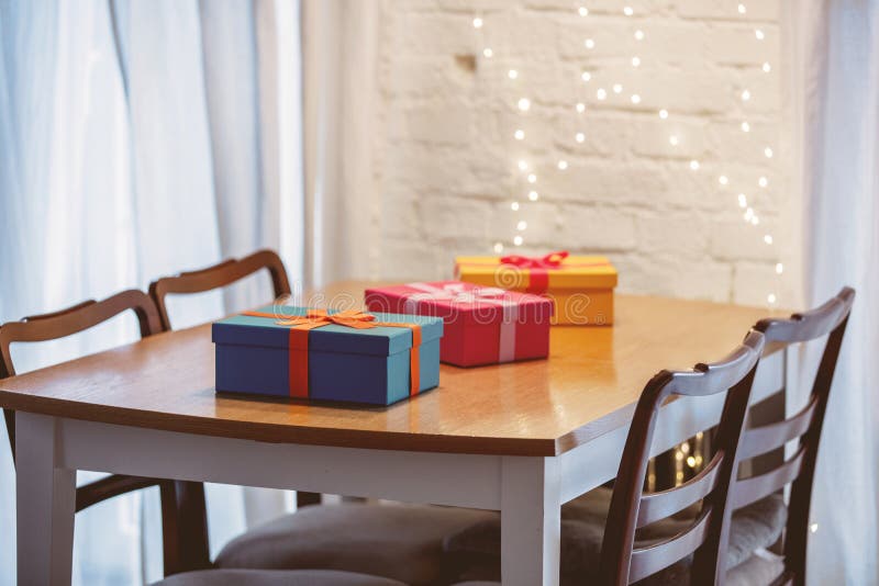 Colored Gift Boxes on Table with Christmas Lights Stock Image - Image ...