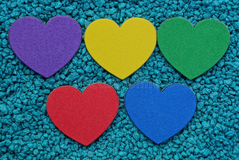 A Row of Colored Hearts on Blue Small Stones Stock Image - Image of ...