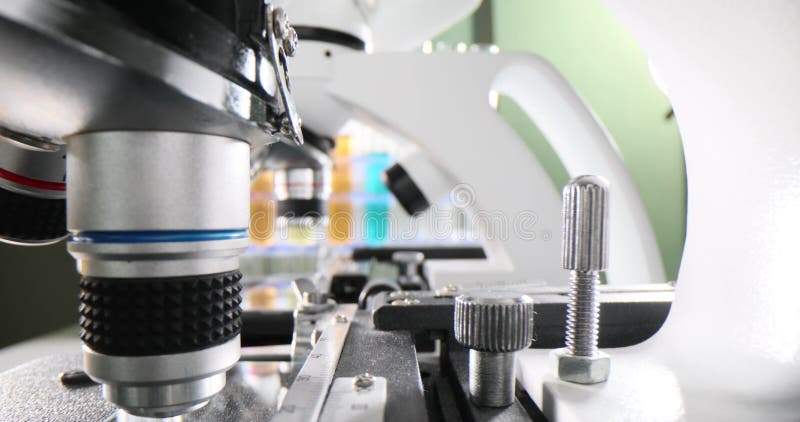 Colored Liquid Laboratory Test Tubes and Row of Microscopes in ...
