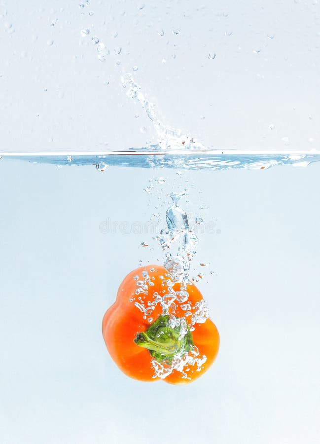 Colored Orange Paprika in Water Splashes on Blue Background Stock Image ...
