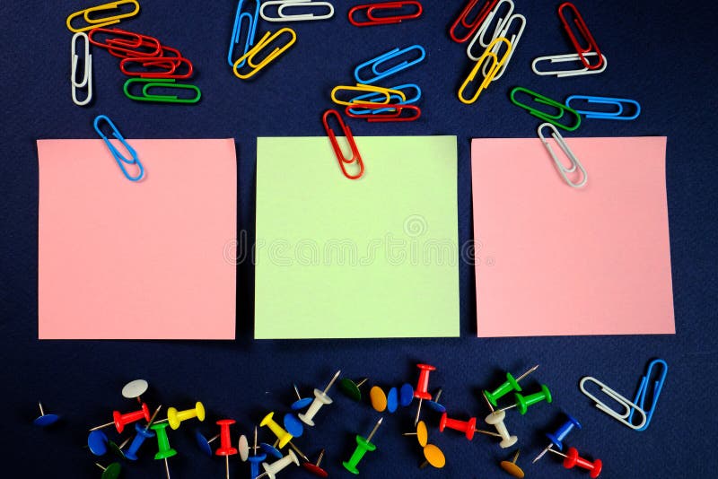 Colored Paper Clips, Button and Stickers on a Dark Blue Background ...