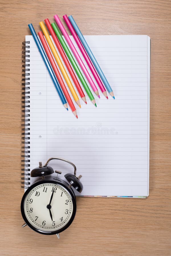 Colored Pencils with Alarm Clock on Blank Notebook Stock Image - Image ...