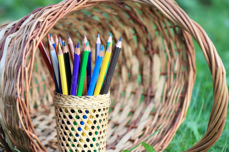 Colored Pencils with a Basket of Knowledge on the Grass Stock Photo ...