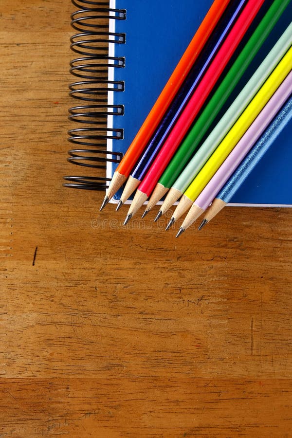 Colored Pencils and a Notebook on a Table Stock Image - Image of spiral ...