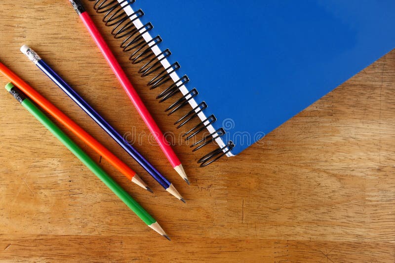 Colored Pencils and a Notebook on a Table Stock Photo - Image of blue ...
