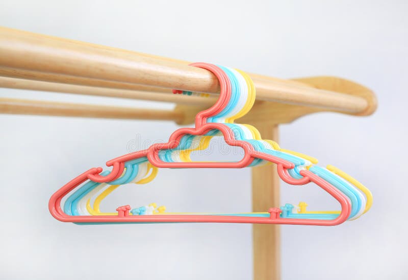 Colored Plastic Clothes Hangers on Wooden Clothes Line Against White ...