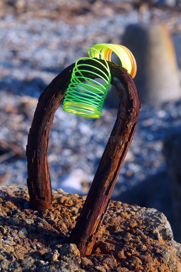 Colored Plastic Spring on a Rusty Loop of Reinforced Concrete Shore ...