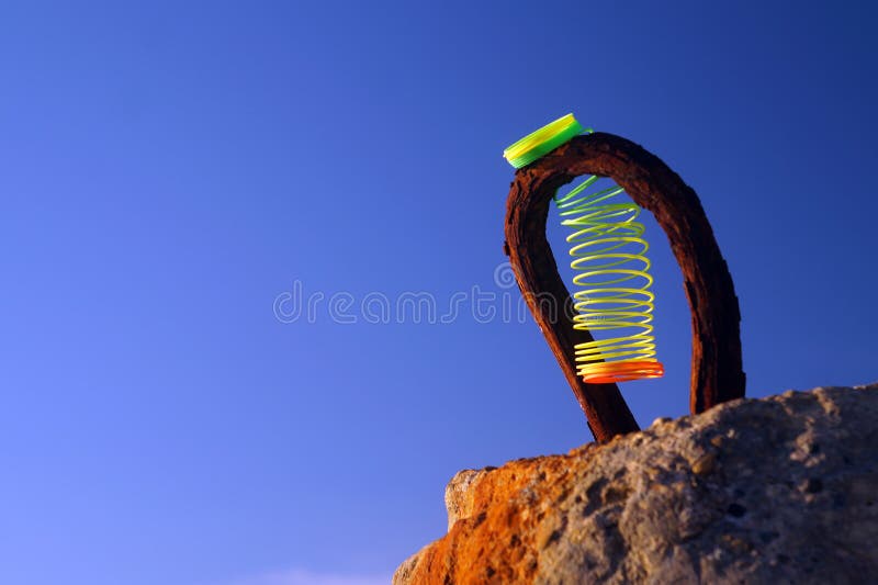 Colored Plastic Spring on a Rusty Loop of Reinforced Concrete Shore ...
