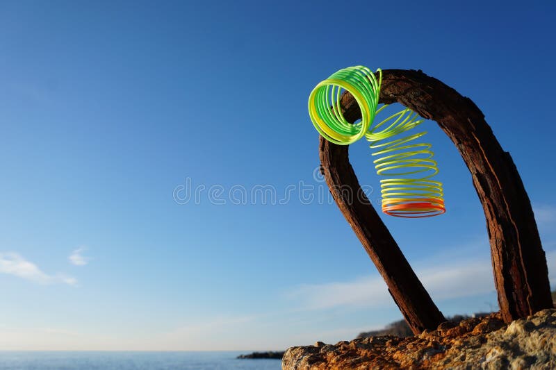 Colored Plastic Spring on a Rusty Loop of Reinforced Concrete Shore ...