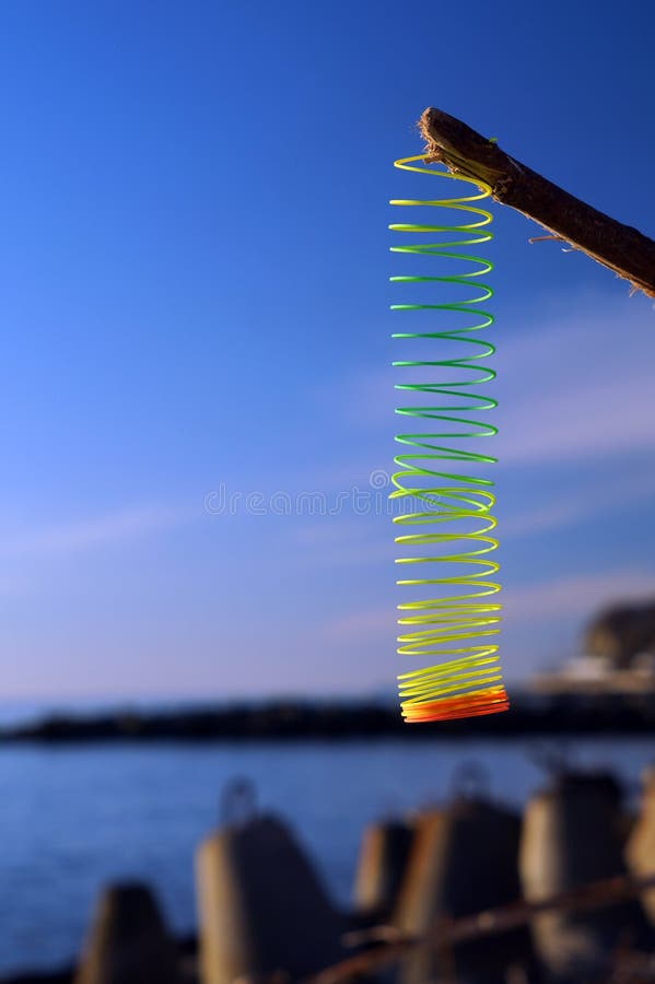 Colored Plastic Spring on a Rusty Loop of Reinforced Concrete Shore ...