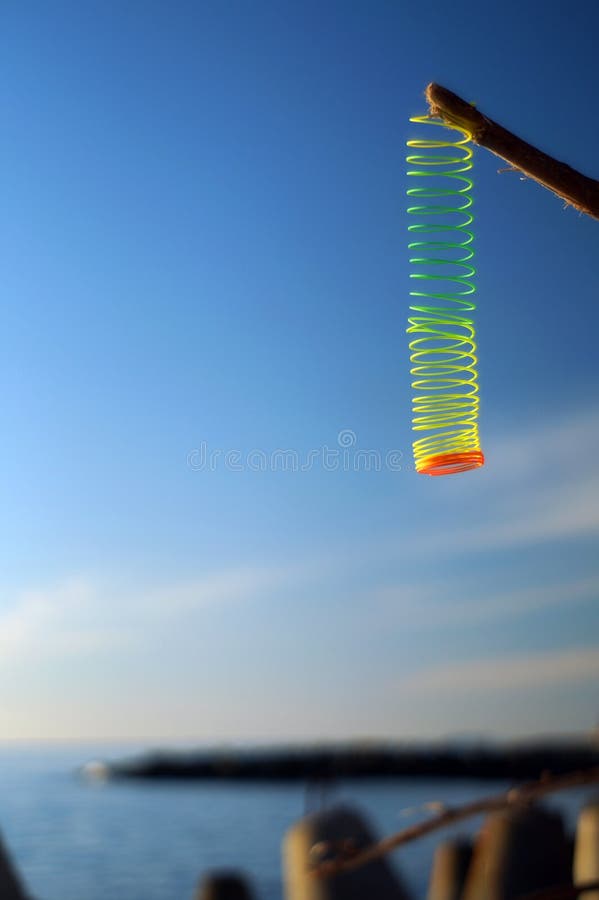 Colored Plastic Spring on a Rusty Loop of Reinforced Concrete Shore ...