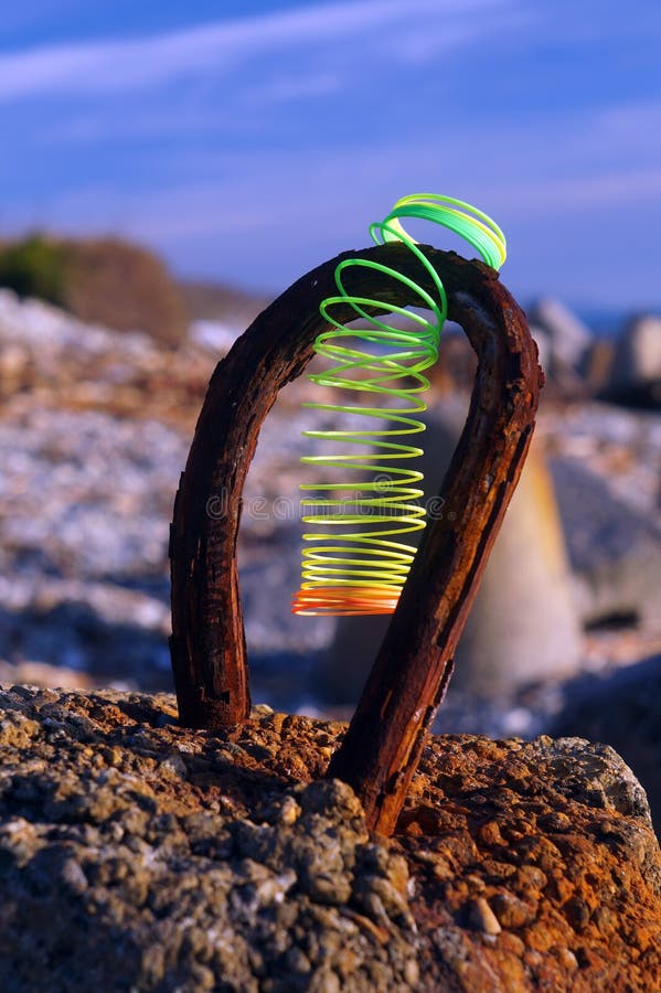 Colored Plastic Spring on a Rusty Loop of Reinforced Concrete Shore ...