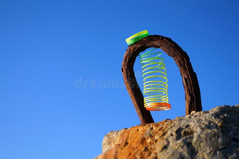 Colored Plastic Spring on a Rusty Loop of Reinforced Concrete Shore ...