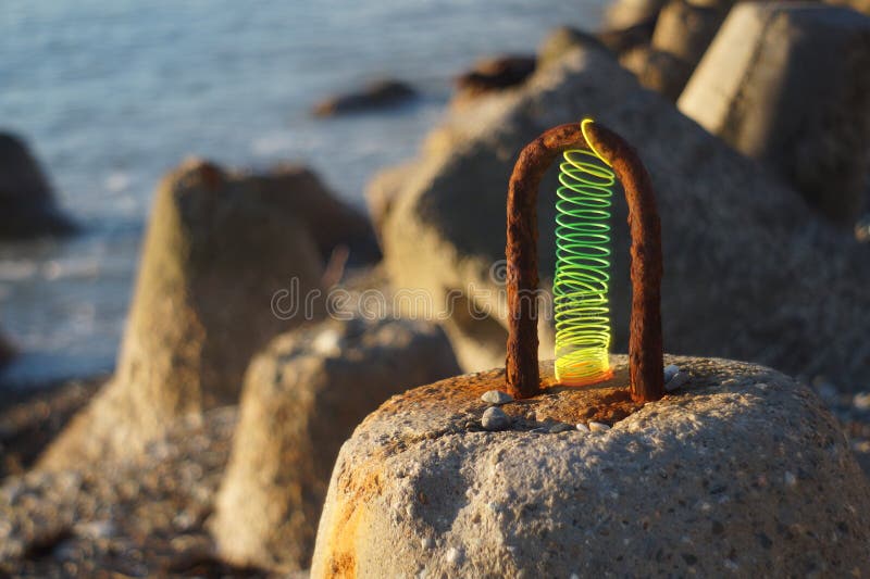 Colored Plastic Spring on a Rusty Loop of Reinforced Concrete Shore ...