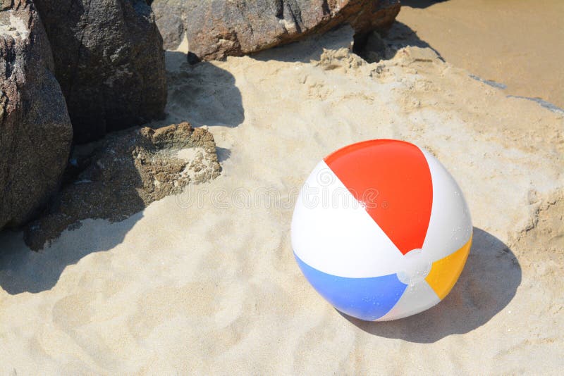 Colorful Beach Ball on Sand Near Rocks, Space for Text Stock Photo ...