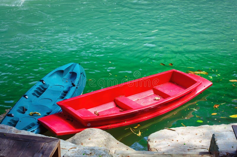 Colorful Blue and Red Canoe Boat in Emerald Green River Stock Photo ...