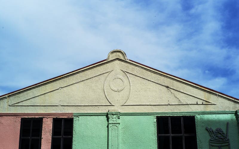 Colorful Building Facade with Triangular Pediment and Decorative Oval ...