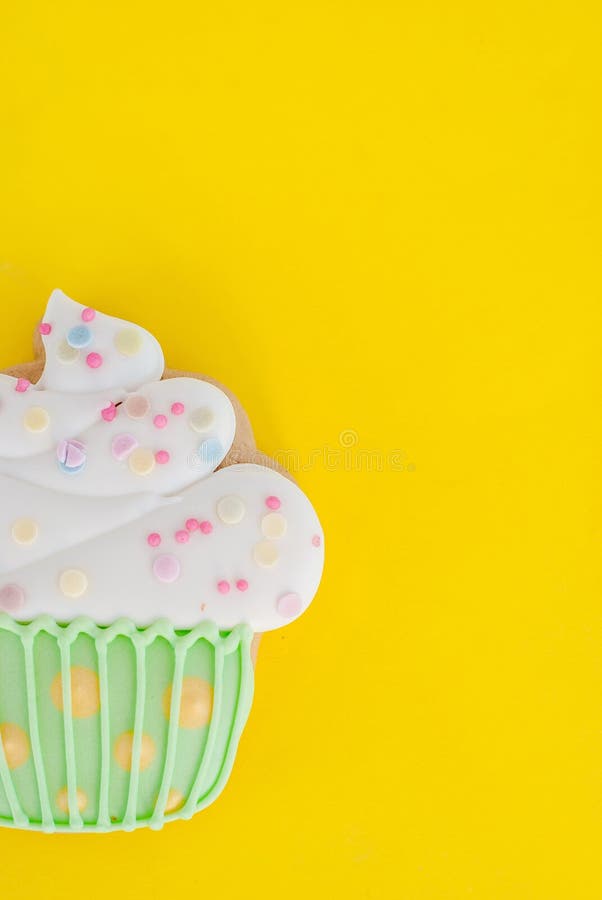 Colorful Icing Cookie in Cupcake Shape on Yellow Background Stock Photo ...