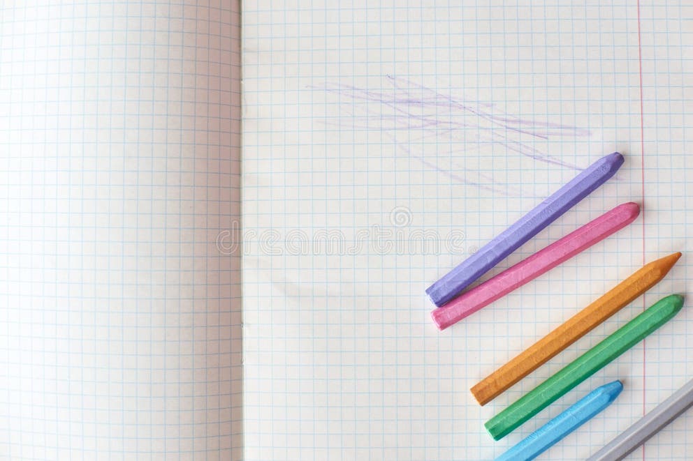 Colorful Crayons Lined Up on Opened Graph Paper Notebook with Abstract ...