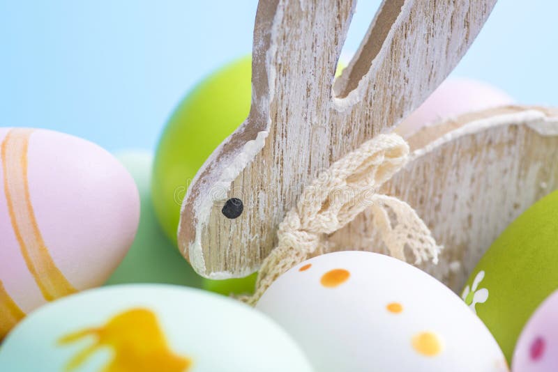 Colorful Easter Eggs and Wooden Rabbit. Cute Rabbit among Easter Eggs ...
