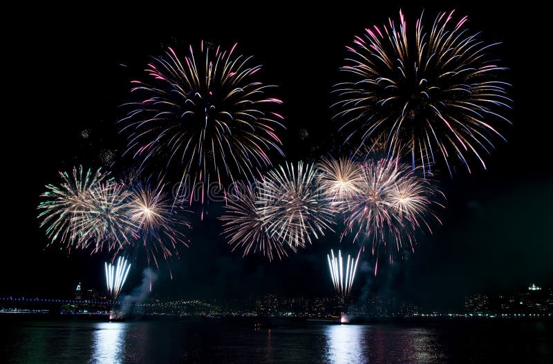 Colorful Fireworks Exploding Over City Skyline Reflecting Water Stock ...