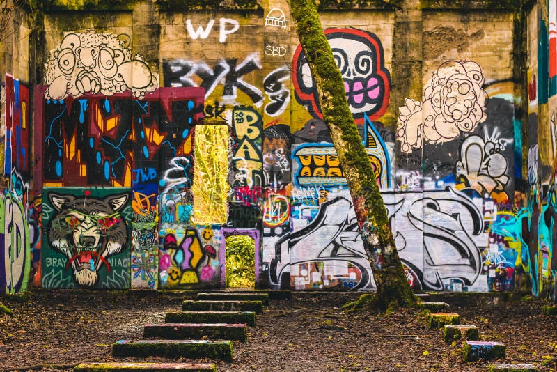 Colorful Graffiti on an Abandoned Wall with a Tree, Stones and Litter ...