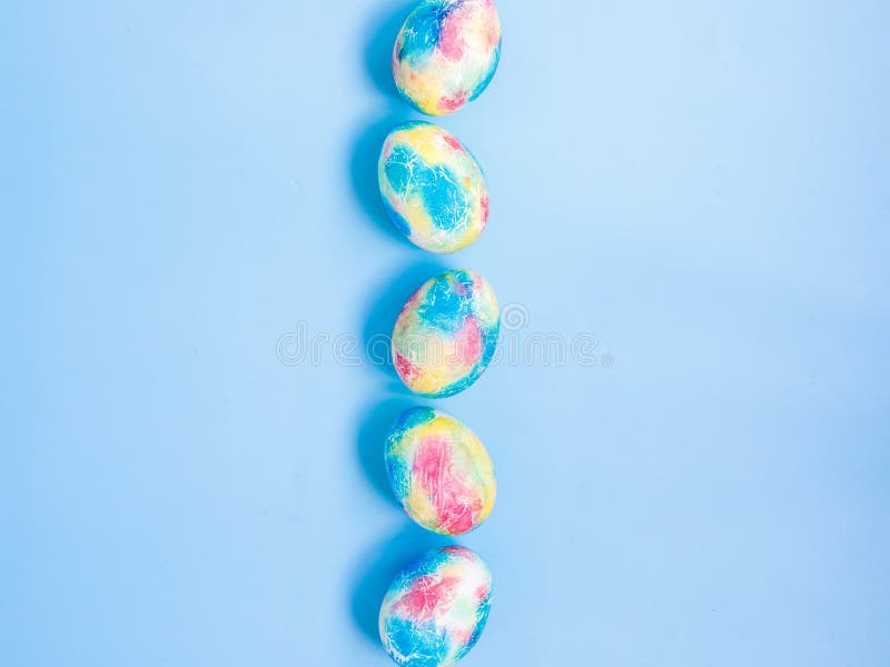 Colorful Handmade Easter Eggs Painted Like Earth in Row on Blue Paper ...