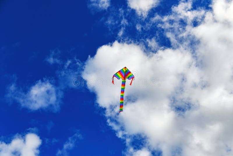 A Colorful Kite Soars among the Blue Cloudy Sky Stock Image - Image of ...