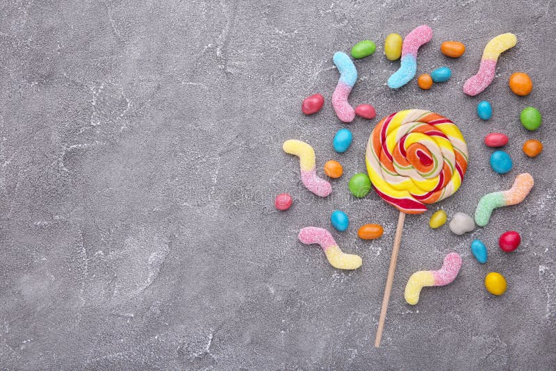 Colorful Lollipop and Different Colored Round Candy on Grey Background ...