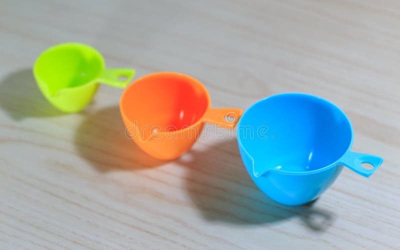 Colorful Measuring Cups Isolated on Wooden Table Background Stock Image ...