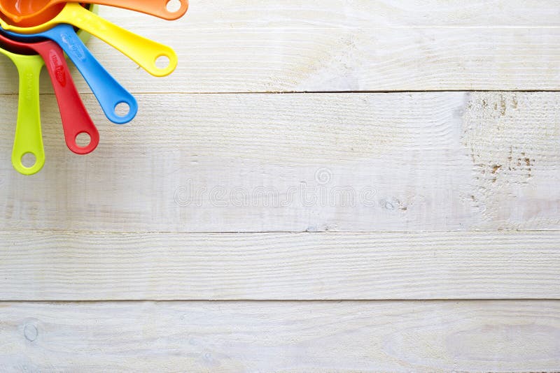 Colorful Measuring Spoons for Kitchen on a White Wooden Background ...