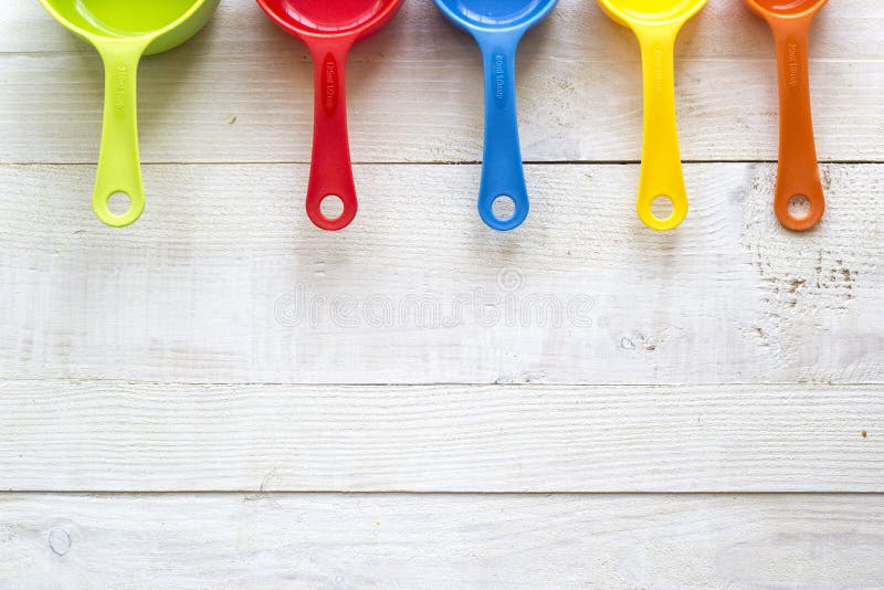 Colorful Measuring Spoons for Kitchen on a White Wooden Background ...