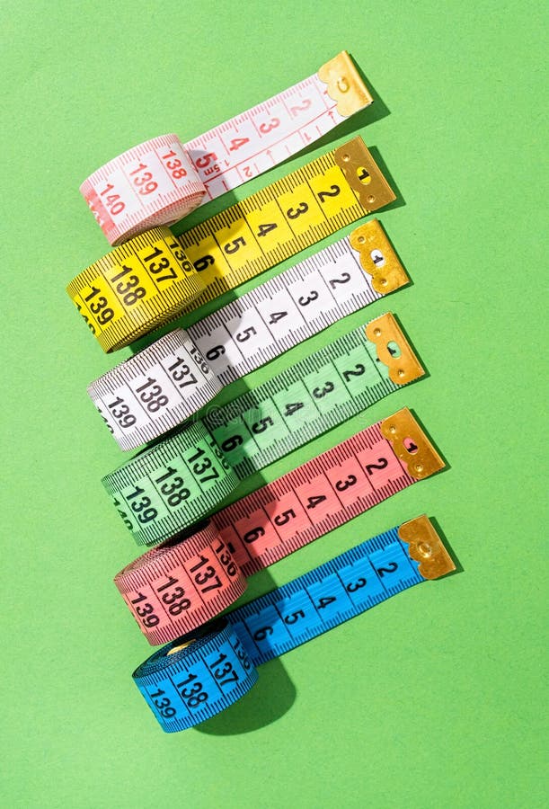 Colorful Measuring Tapes Top View on Bright Green Background Stock ...
