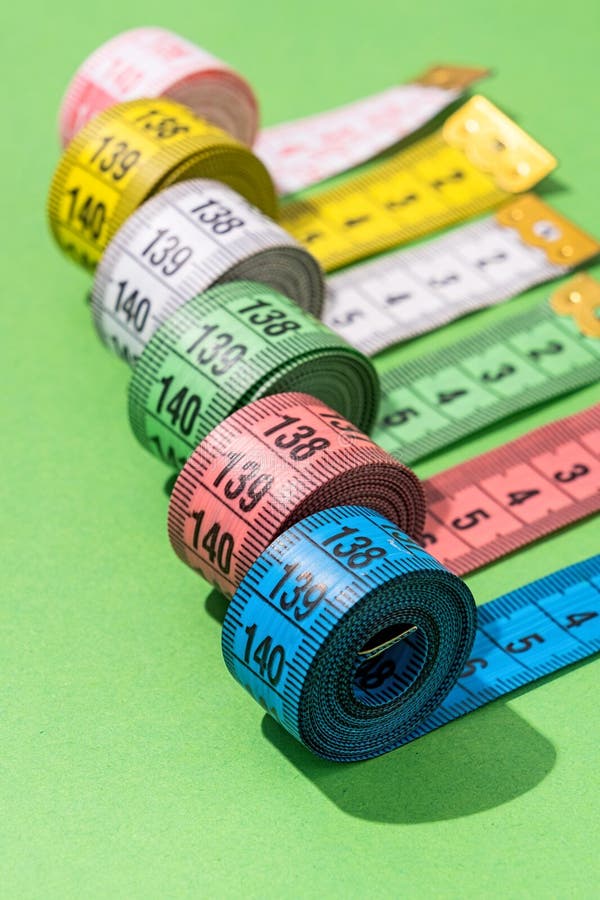 Colorful Measuring Tapes Top View on Bright Green Background Stock ...
