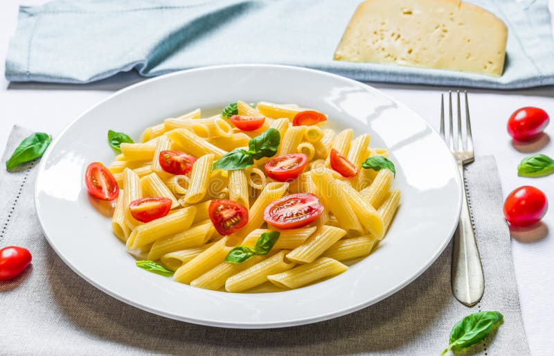 Colorful Penne Rigate Pasta Dish with Cherry Tomatoes and Basil Leaves ...