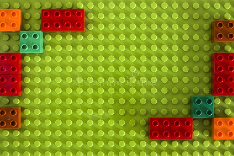 Colorful Plastic Building Blocks on a Green Matwith Empty Copyspace ...