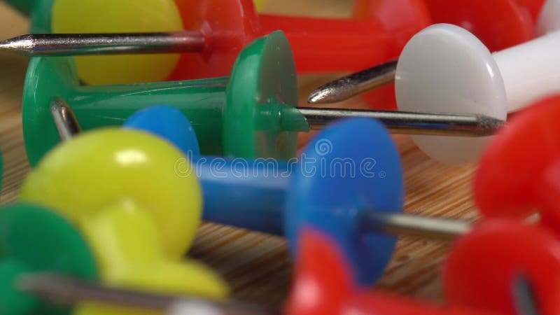 Colorful Push Pins Rotating on the Table Macro. Drawing Pins for ...