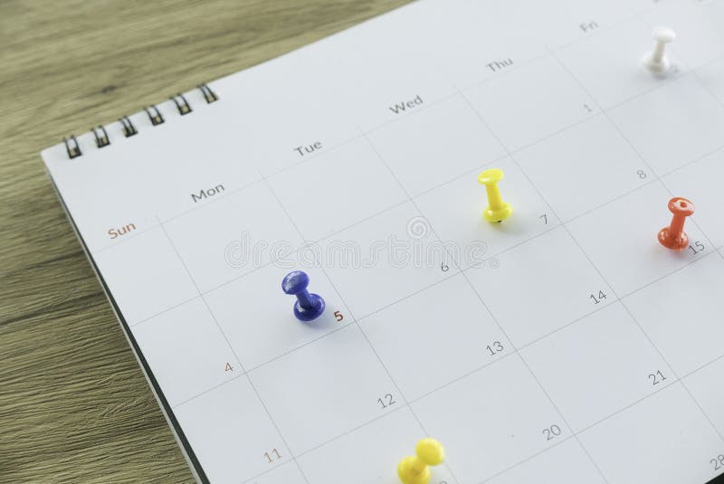 Colorful Push Pins on a Spiral-Bound Calendar Page for Planning and ...