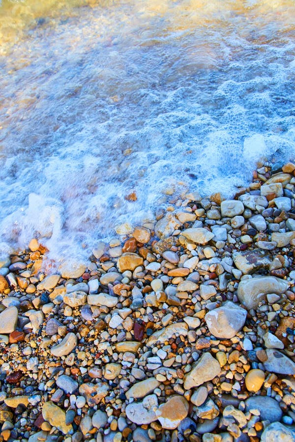 Colorful Rocks and Pebbles with Frothy Waves on Beach Lake Shore Stock ...