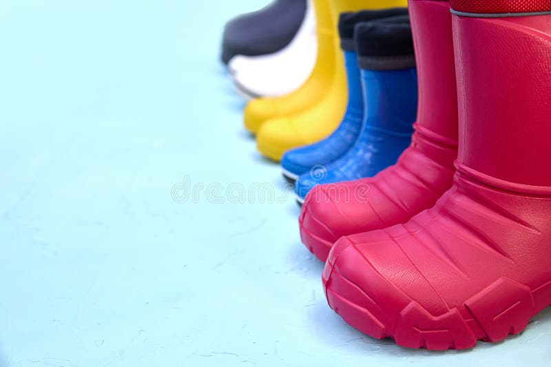 Vibrant Rubber Boots in Line on Blue Surface Stock Photo - Image of ...