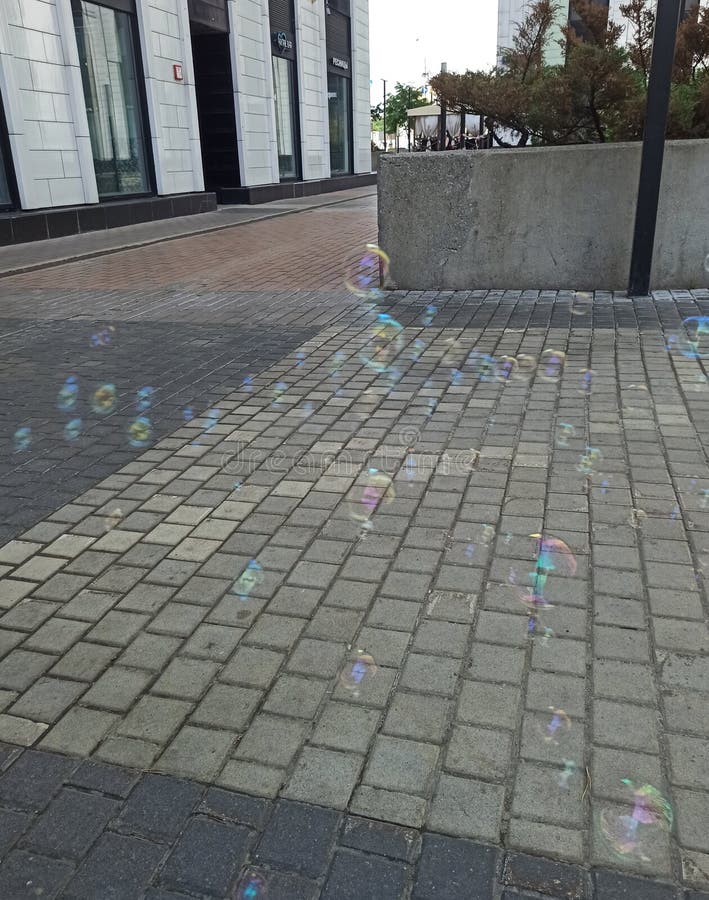 Colorful Soap Bubbles Float Gently Above a Cobblestone Pathway in a ...